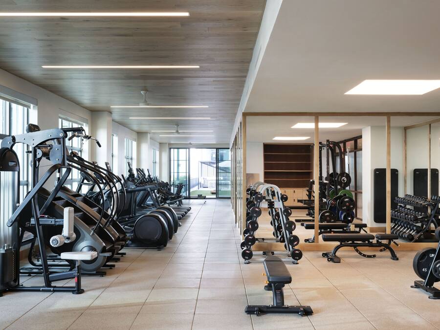 Academia com esteiras, elípticos e aparelhos de musculação.