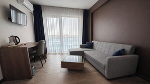 Uma sala de estar moderna com um sofá, mesa de centro e escrivaninha com cadeira.