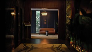 Um interior moderno com um sofá, uma mesinha e um candelabro.