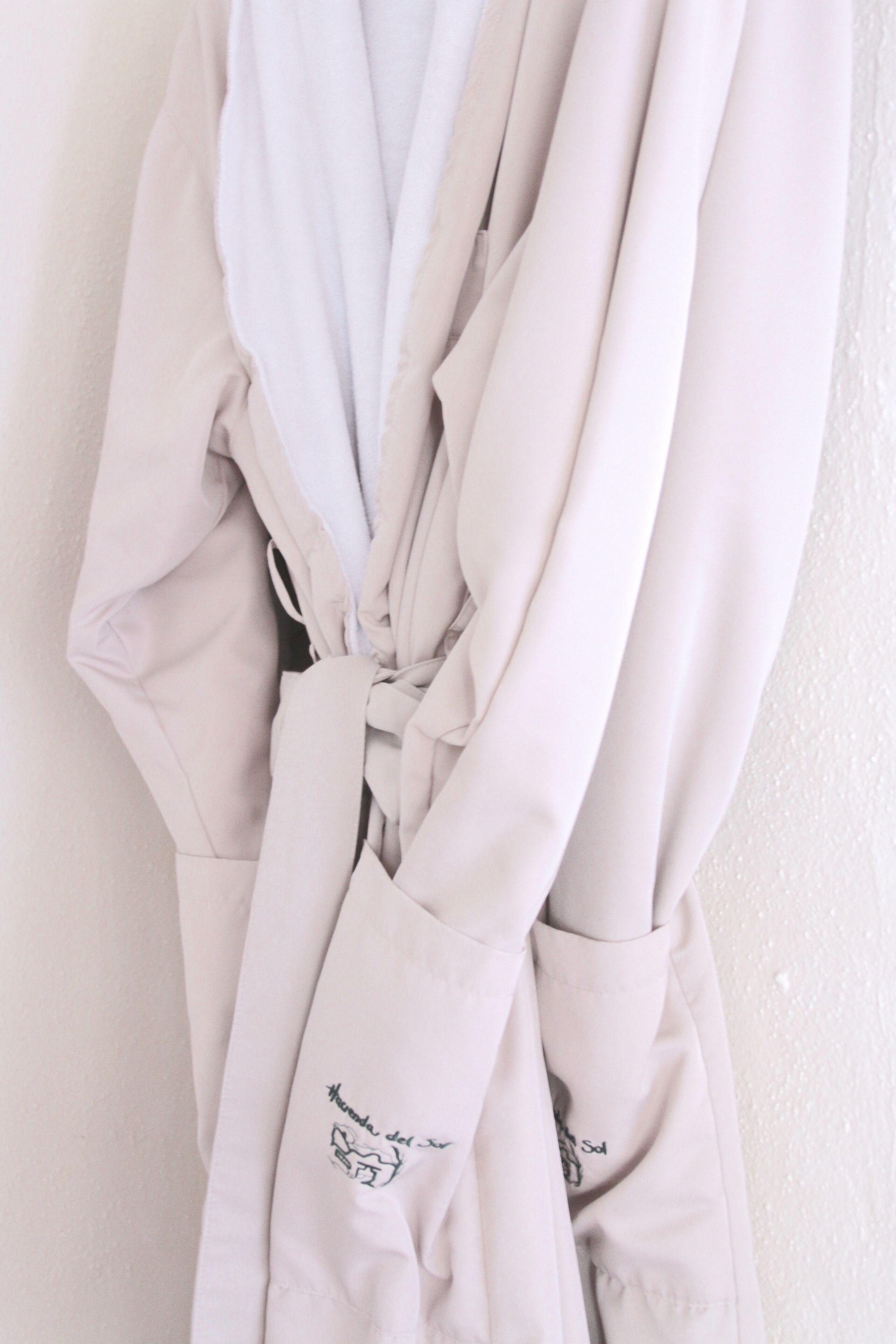 Um robe branco amarrado em um nó na parede.
