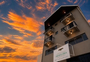 Um edifício com uma placa que diz 'Pousada Araujo Campos do Sol', indicando um hotel.