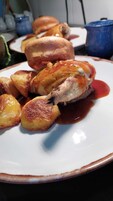 Um prato com frango assado, batatas e molho.