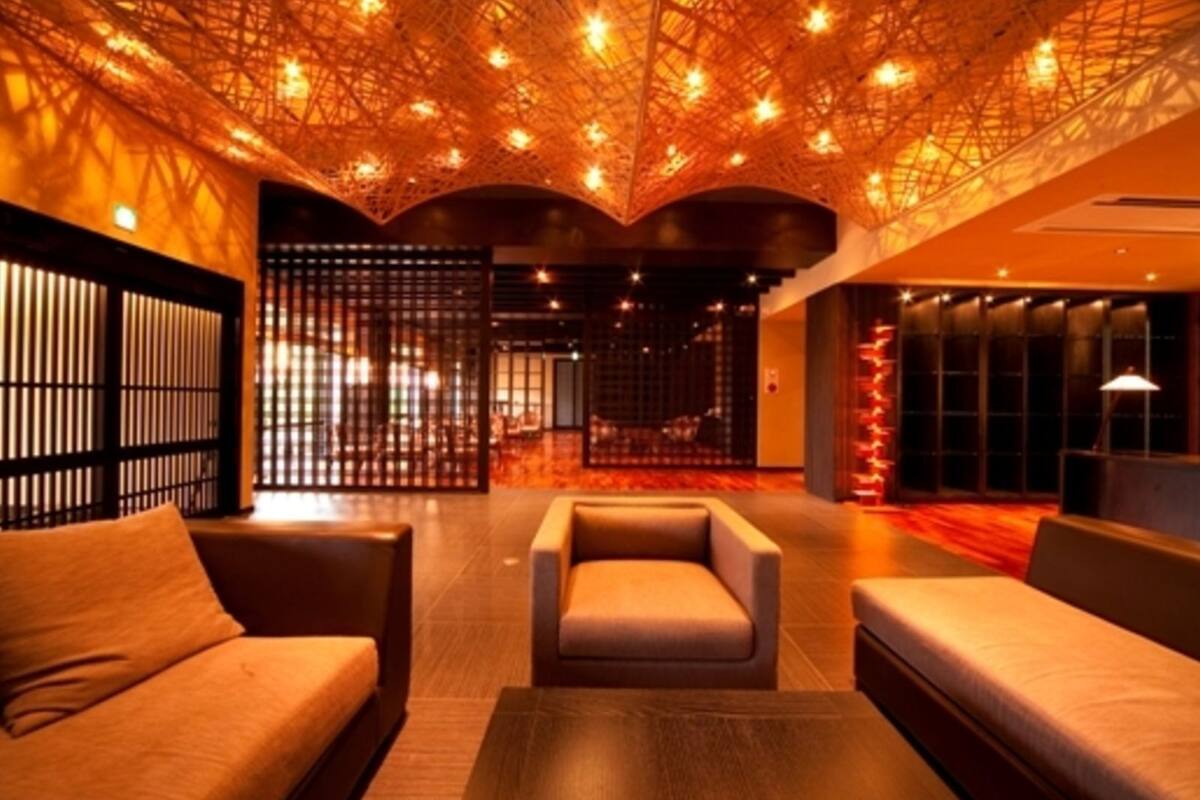 Interior moderno com teto alto, área de estar e parede decorativa com padrão quadriculado.