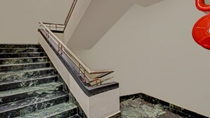 Escadaria com degraus de mármore e corrimão de metal.
