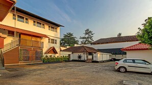 Um edifício com escadaria, um carro e uma placa que diz 'HOTEL PENI'.