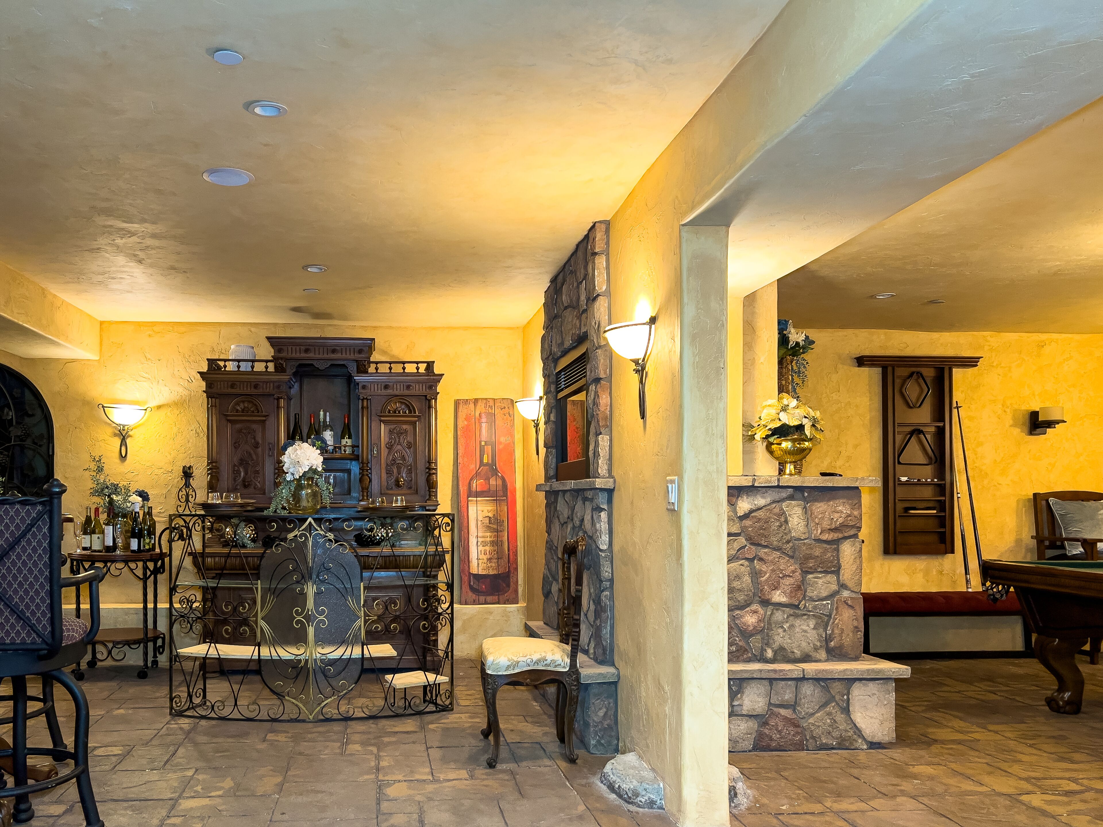 Um interior acolhedor com área de bar, lareira de pedra e espaço para refeições.