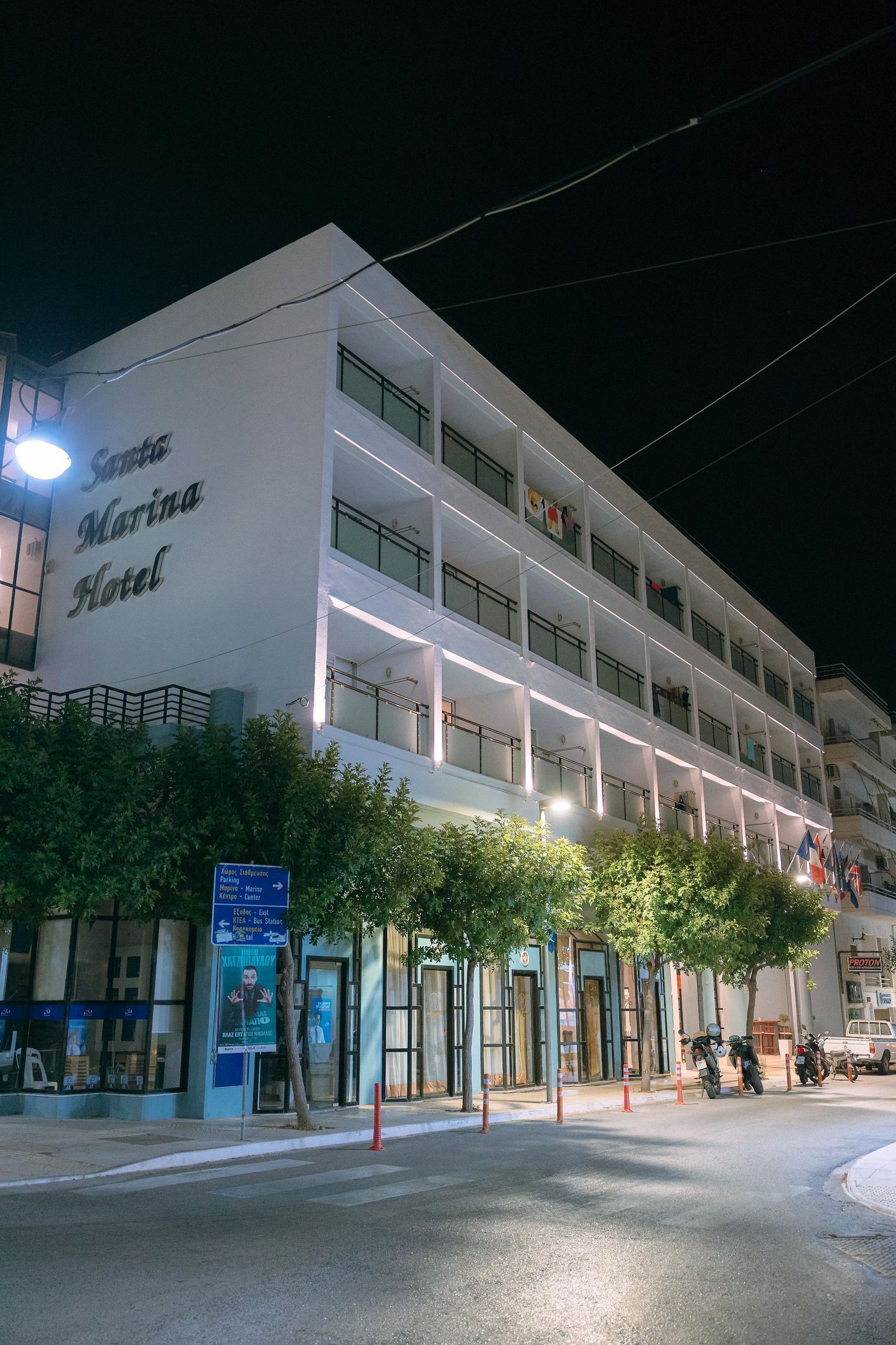 Um hotel com vários andares, com varandas e uma placa com a inscrição 'Santa Marina Hotel'.