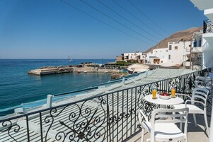 Hotel à beira-mar com varanda e vista para o mar e a costa rochosa.