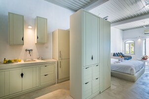 Quarto moderno com uma cama grande, mesa de cabeceira e janela com vista para o verde.