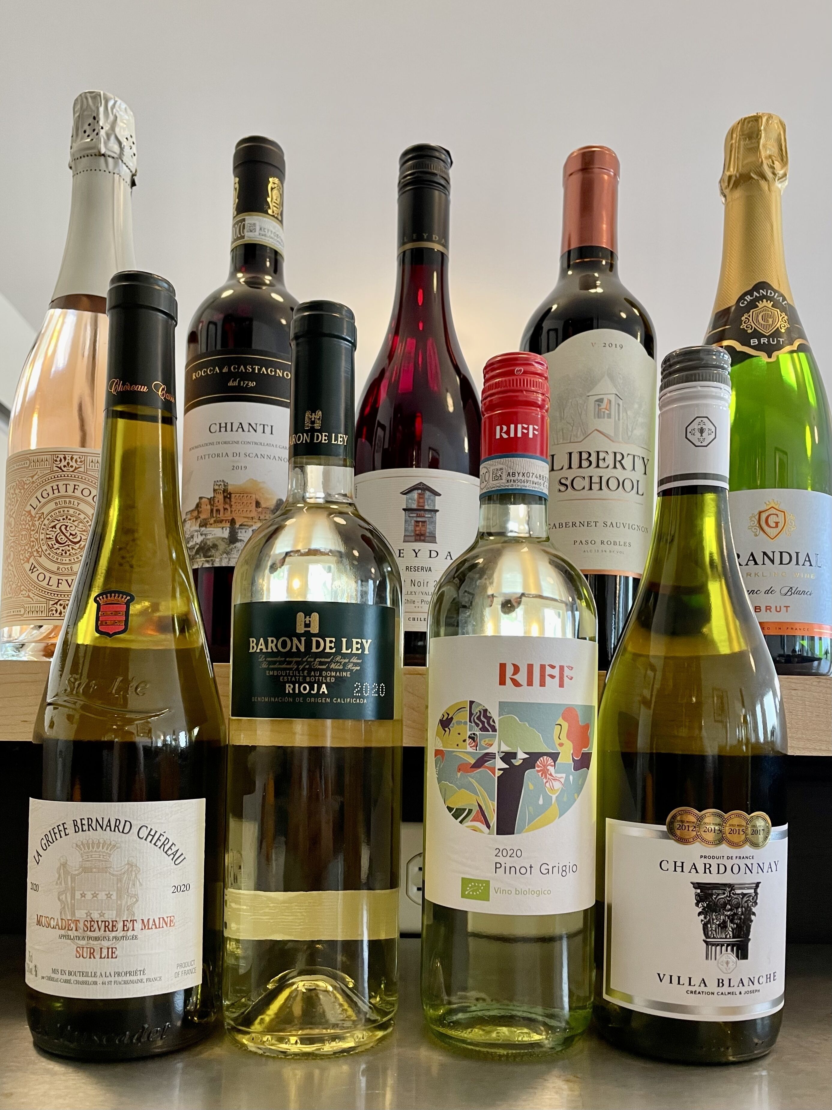 Diversas garrafas de vinho sobre um balcão.