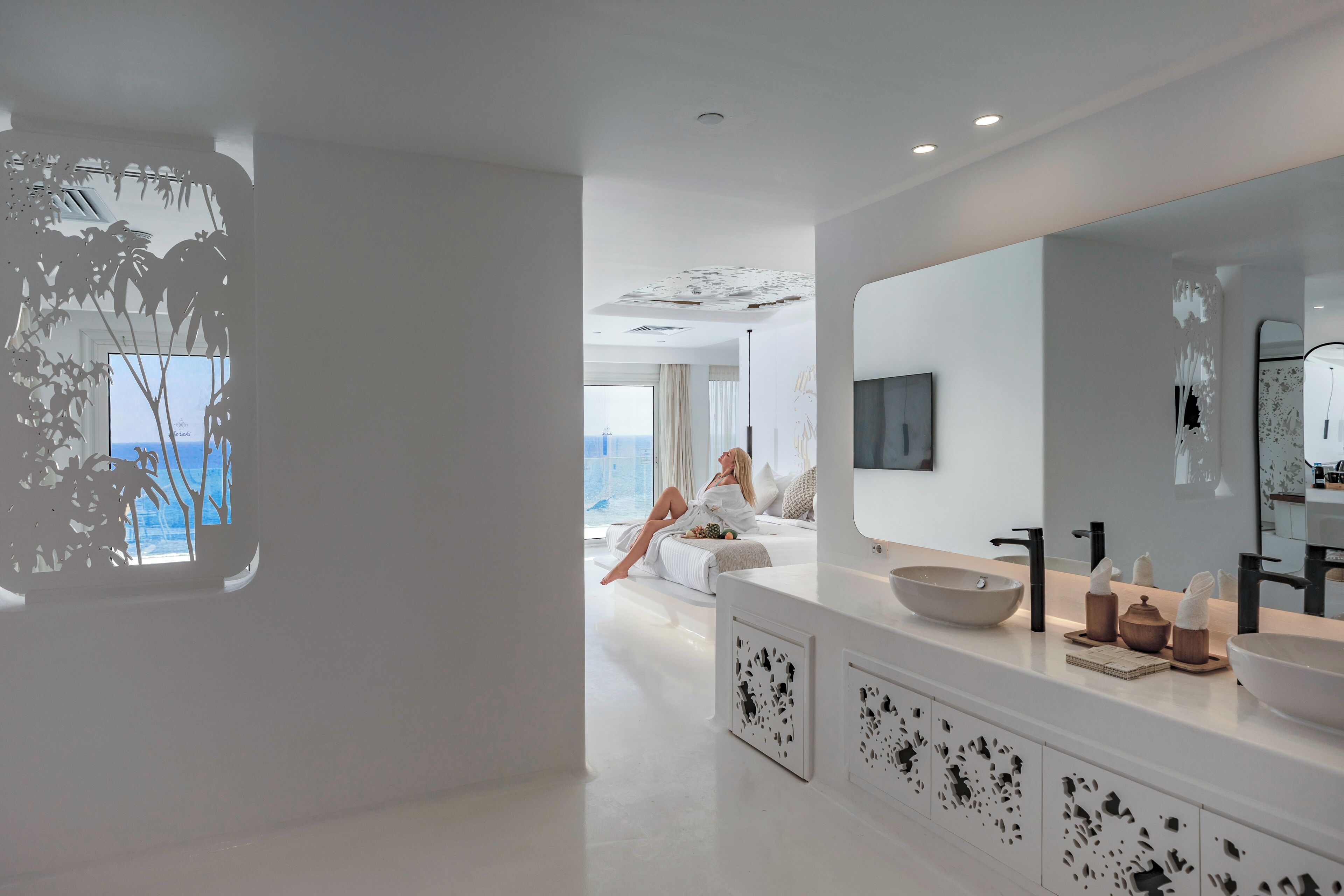 Casa de banho moderna com um espelho grande, toucador branco e lavatório em concha.
