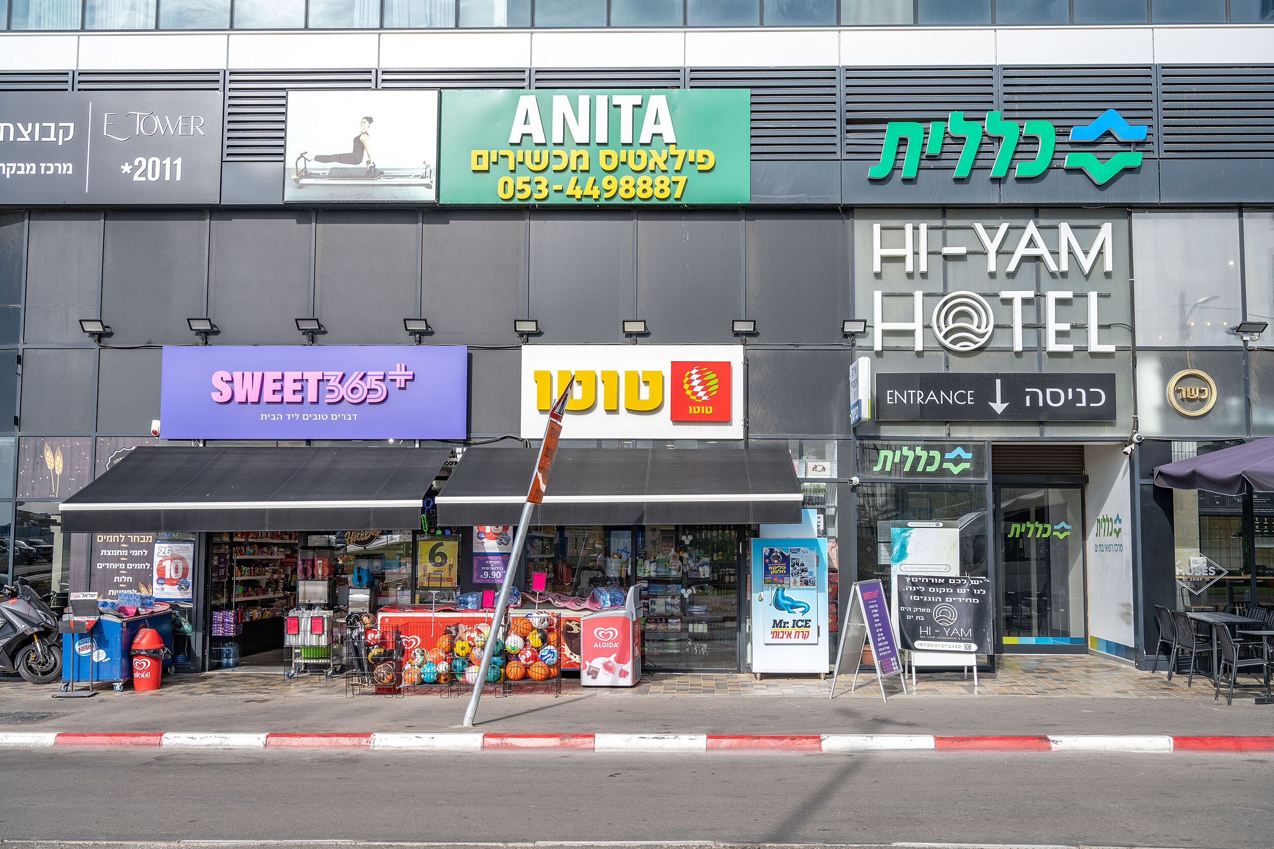 Um edifício com placas para ANITA, HOTEL HI-YAM e SWEET365+.