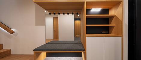 Um quarto moderno, com vários níveis, com estantes de madeira embutidas, um banco e uma escada.