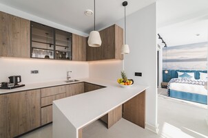 Uma cozinha moderna com bancada branca, armários de madeira e iluminação pendente.