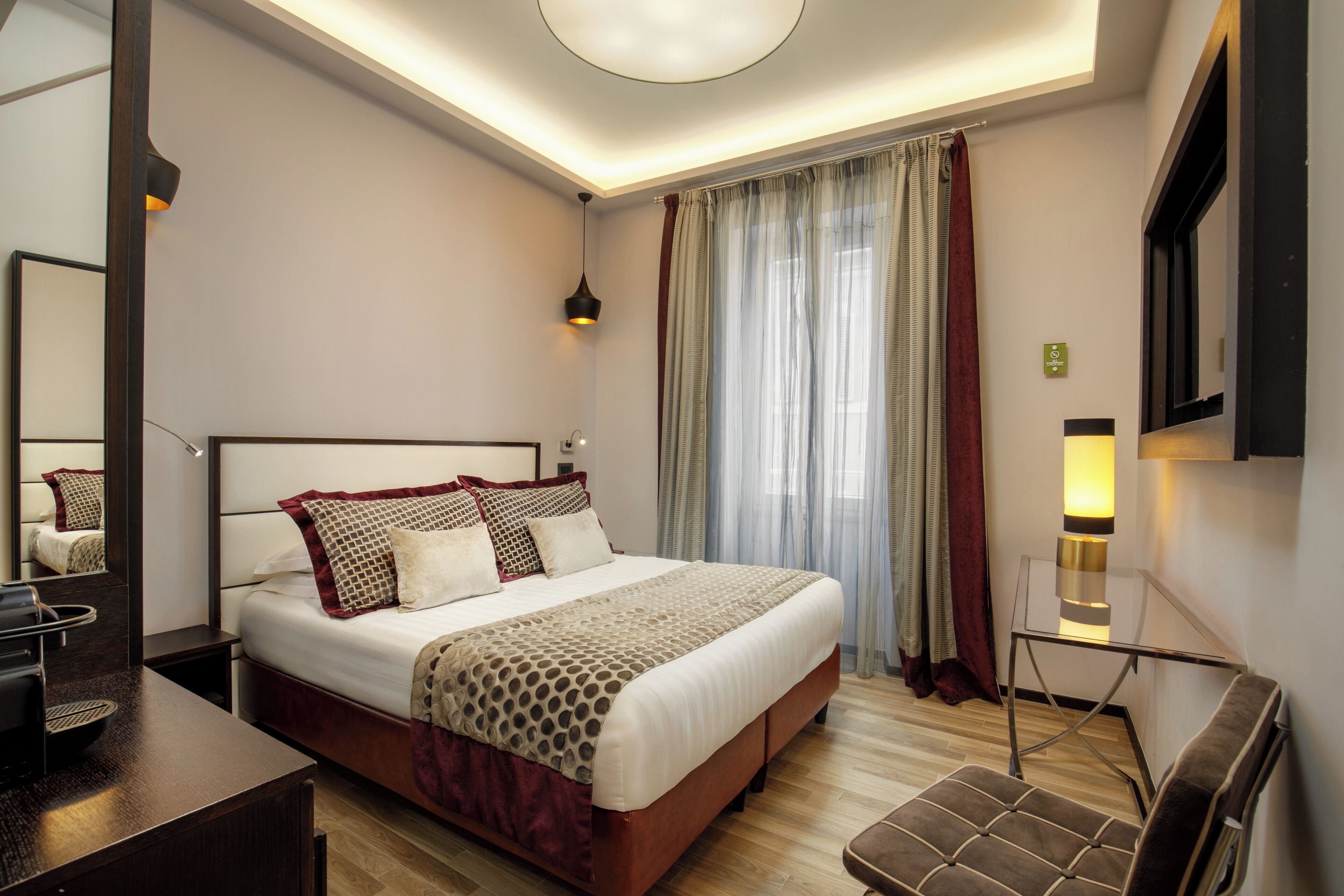 Quarto de hotel moderno com uma cama grande, uma escrivaninha e uma cadeira.