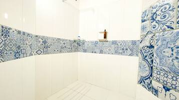 Casa de banho com azulejos brancos e azulejos decorativos azuis nas paredes.