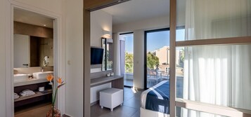 Quarto de hotel moderno com banheiro, área de estar e varanda com vista.