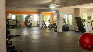 Uma academia com diversos equipamentos de exercícios, incluindo esteiras, bicicletas ergométricas e aparelhos de musculação.