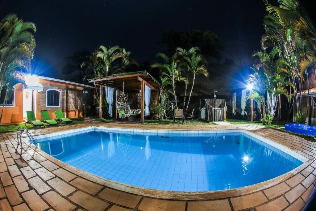 Piscina com borda azulejada, rodeada por um pátio de tijolos.