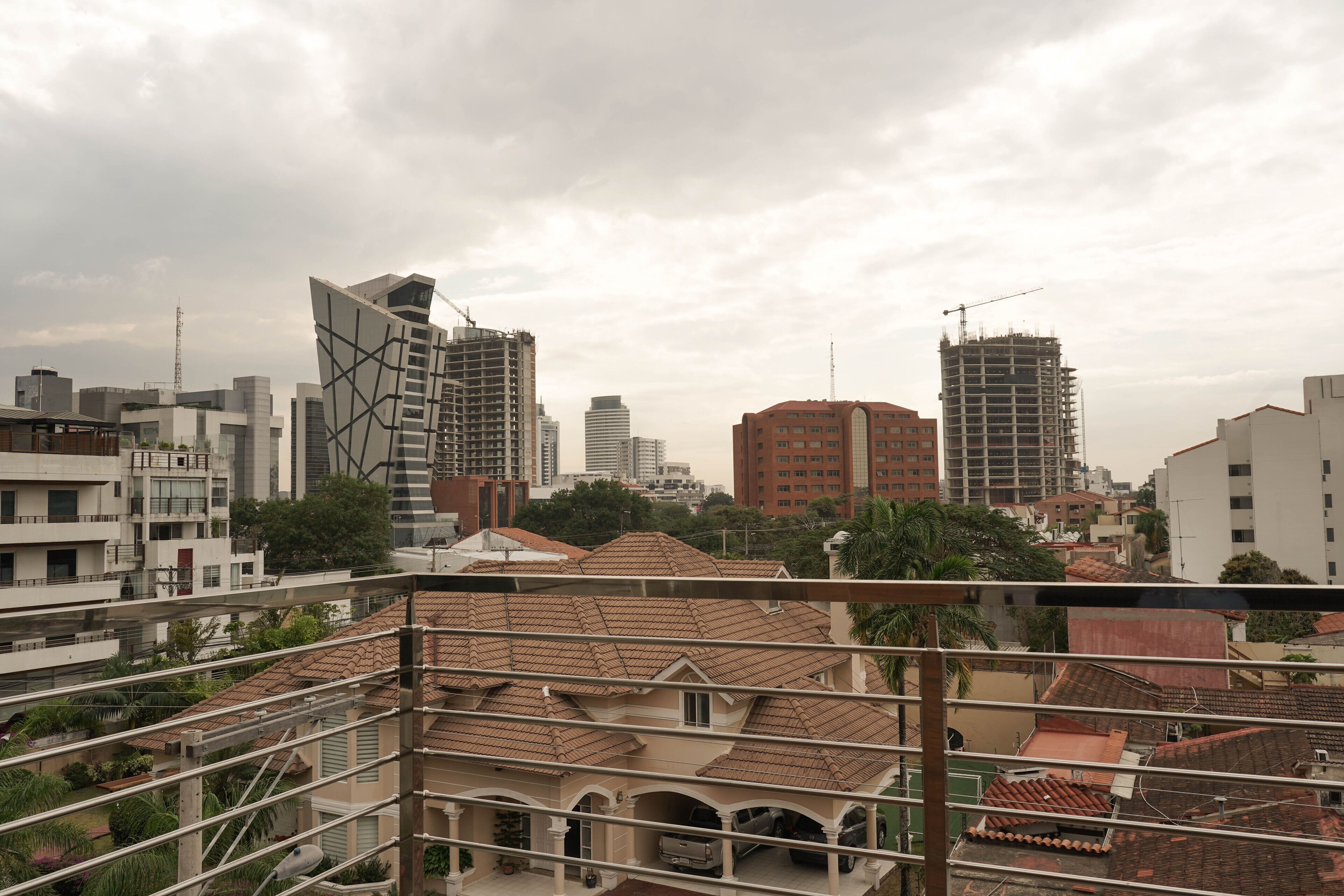 Uma área residencial com arquitetura moderna e tradicional, incluindo uma casa com telhado de cerâmica e um edifício em construção.