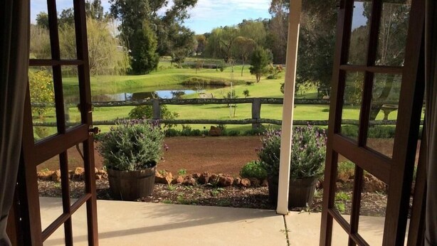Varanda coberta com vista para um campo de golfe.