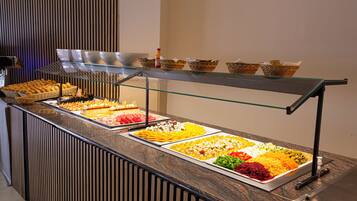 Buffet com diversos alimentos e cestas sobre um balcão.