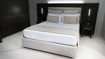 Quarto moderno com cama grande, guarda-roupa escuro e abajures.