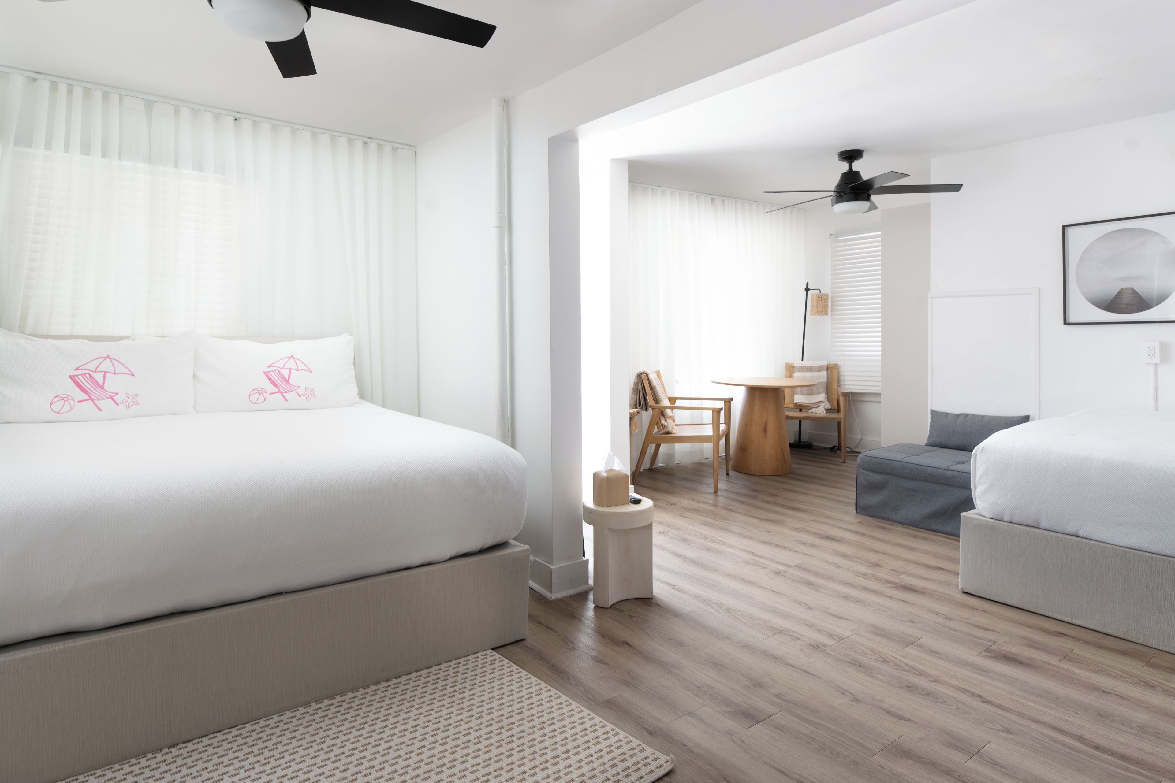 Quarto de hotel moderno com uma cama grande, uma escrivaninha e uma cadeira.