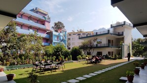 Um pátio com vista clara para um edifício de hotel, área de estar externa e vasos de plantas.