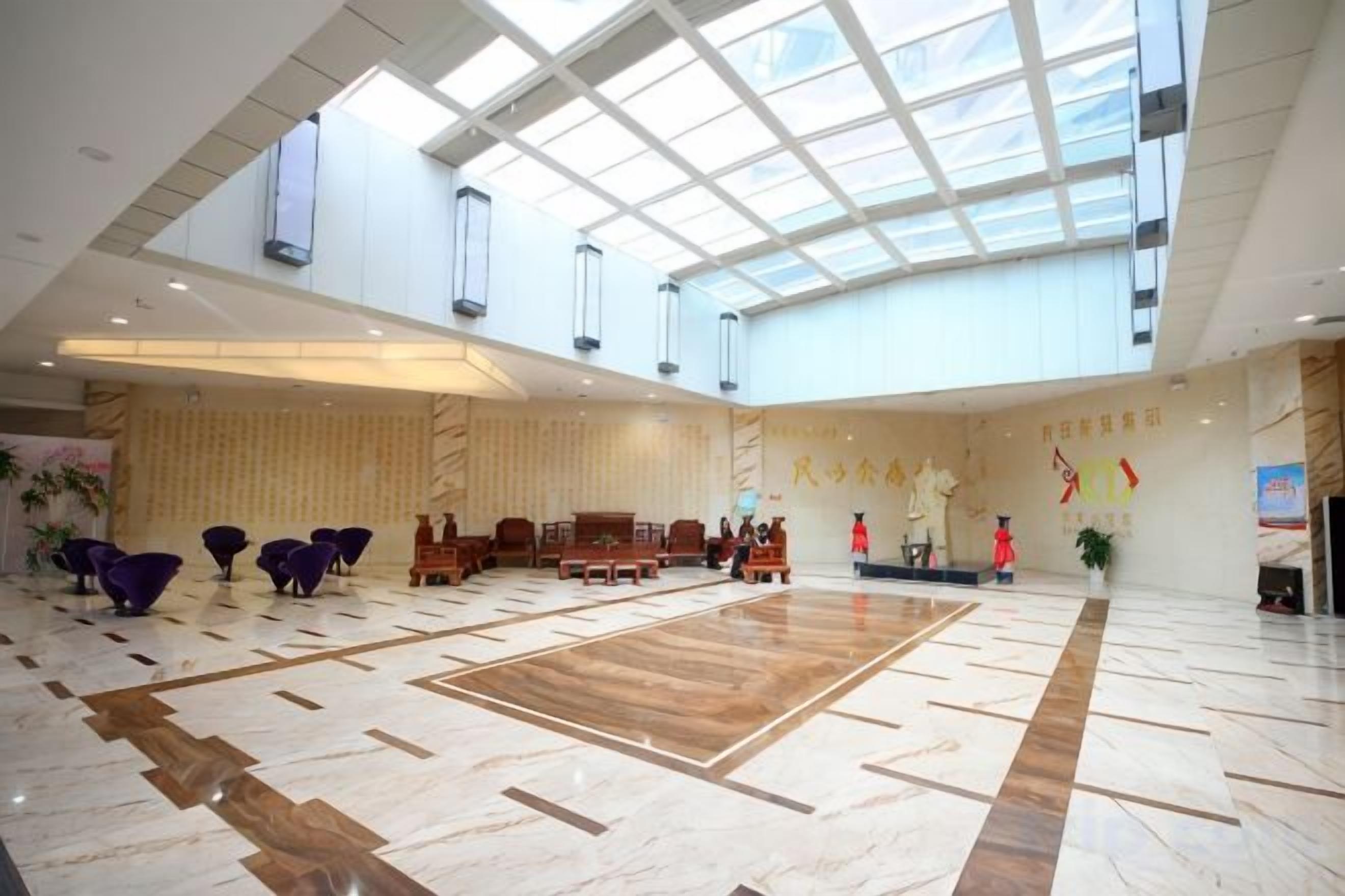 Um hall amplo com teto alto, área central aberta e opções de assento.