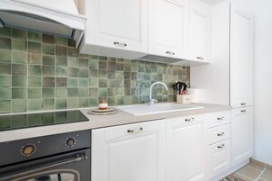 Apartamento, varanda | Cozinha privada | Geladeira grande, fogão, cooktop, lava-louças