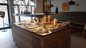 Buffet de café da manhã com diversas opções de comida e uma estação de café.