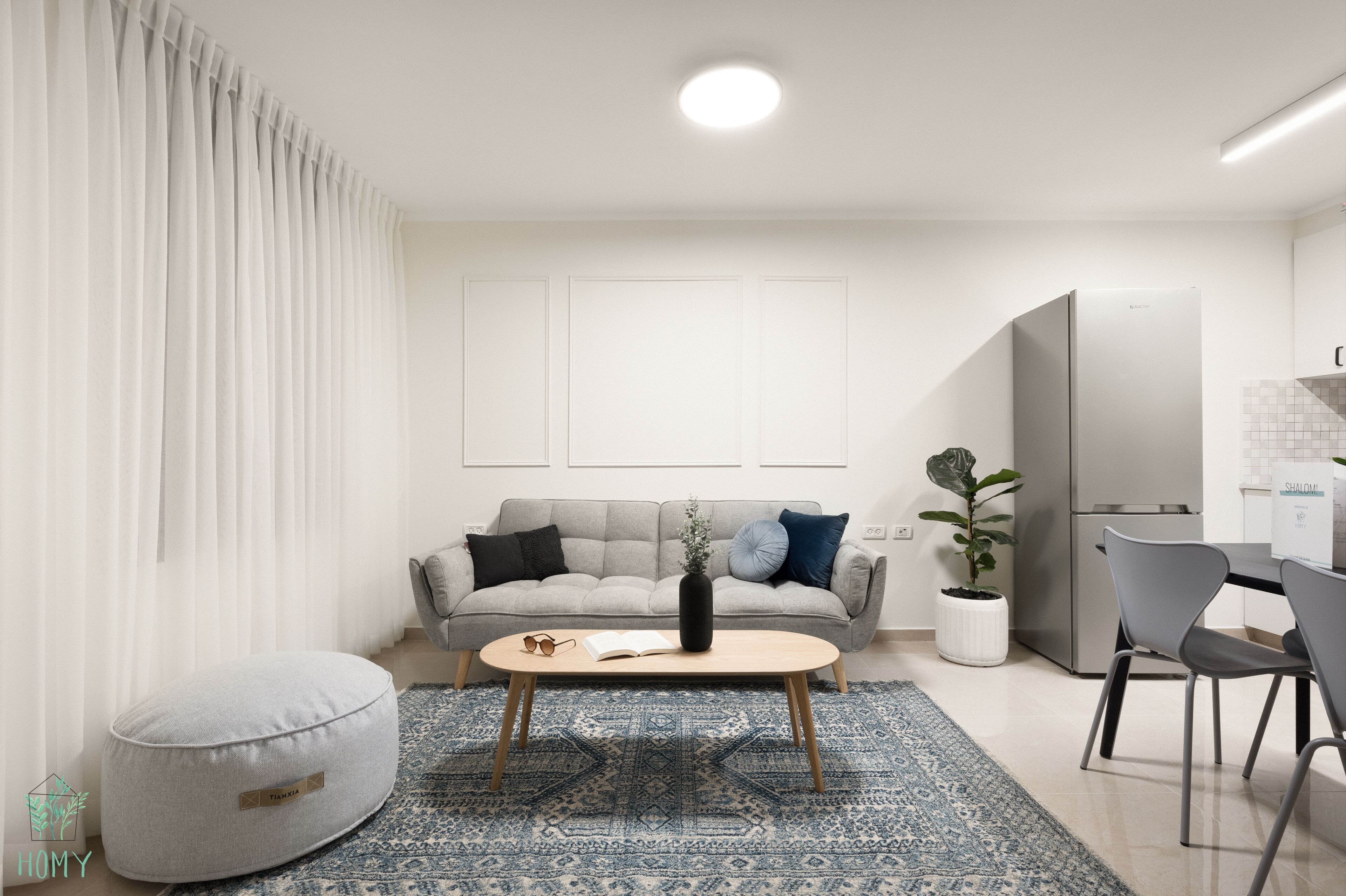 Uma sala de estar moderna com um sofá, mesa de centro e um vaso de plantas.