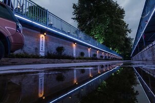 Um canal com uma ponte e um edifício com janelas iluminadas.