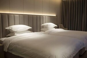 Quarto de hotel com uma cama grande, cabeceira acolchoada e uma cadeira.