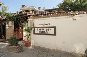 Um edifício com uma placa que diz "OTEL & CAFE SALIH BEY KONAGI".