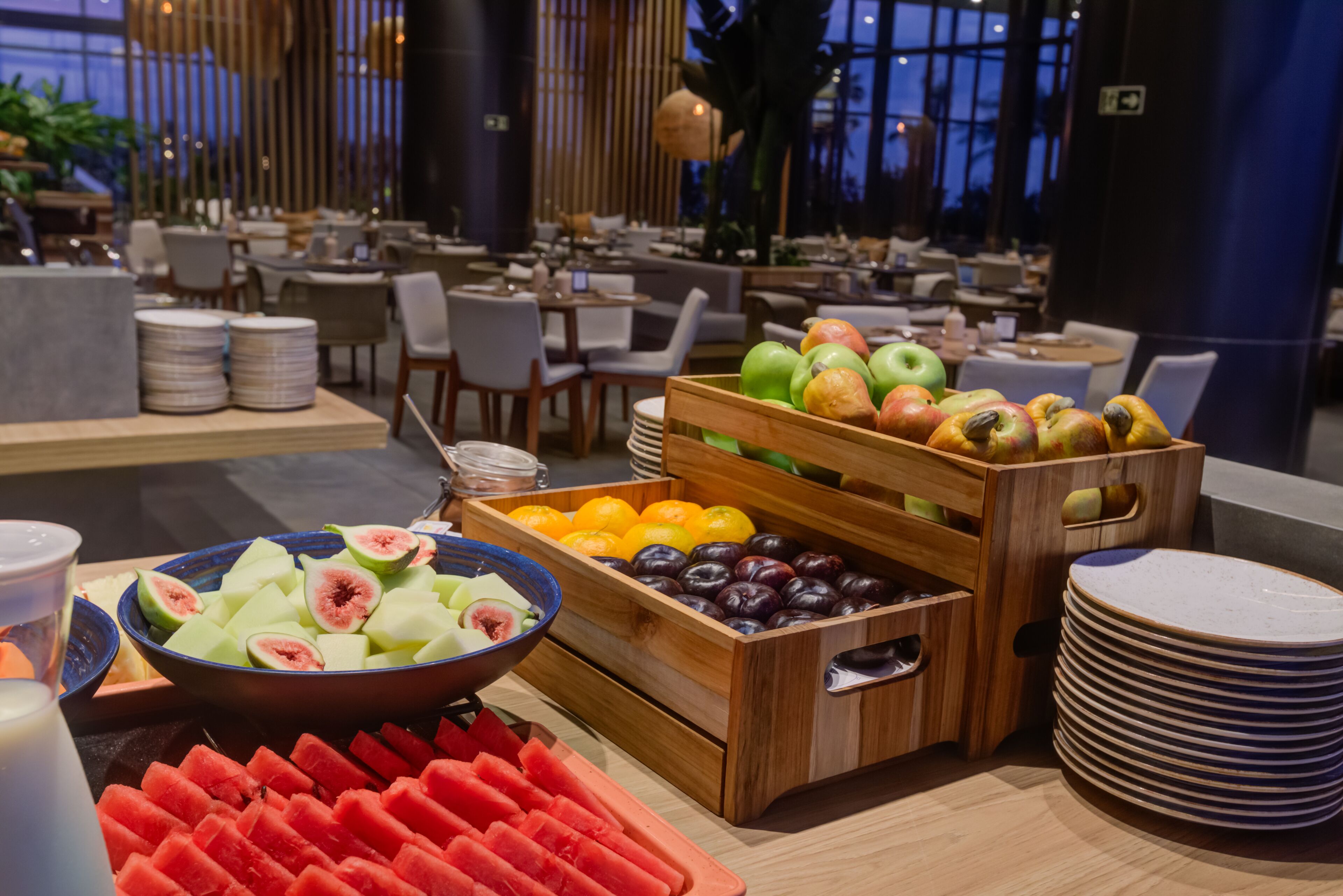 Buffet com diversas frutas e uma tigela de melancia em fatias.