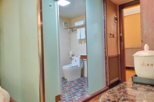 Um banheiro de hotel com piso em azulejos, vaso sanitário e pia.