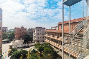 Um edifício com vários andares, um pátio central, área de estar externa e uma escadaria.