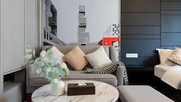 Uma sala de estar moderna com um sofá, uma mesa de centro redonda e um vaso decorativo.