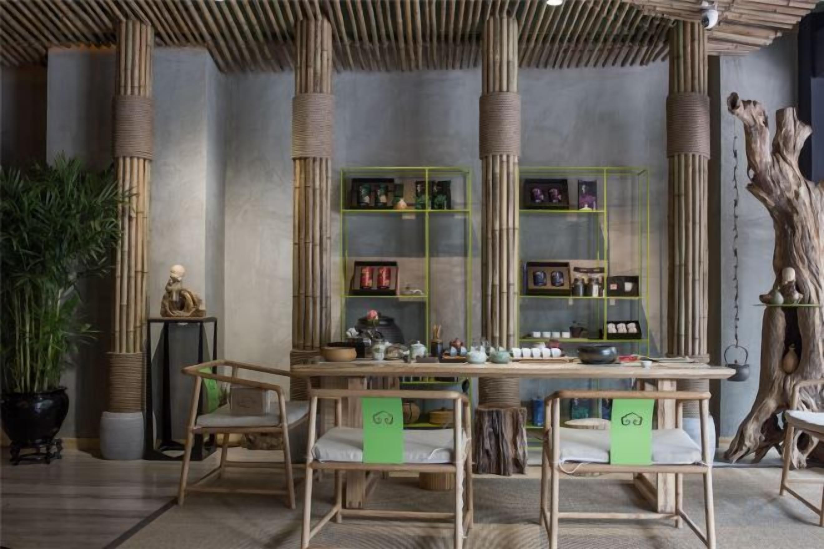 Quarto com teto de bambu, prateleiras emolduradas a verde e uma mesa central com cadeiras.