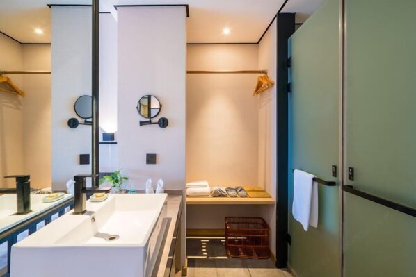 Casa de banho moderna com uma grande pia, duas espelhas e um porta-toalhas.
