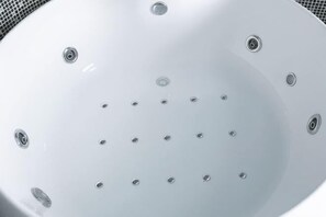 Uma banheira branca com várias torneiras e um chuveiro.
