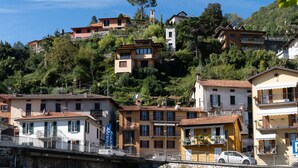 Uma área residencial em encosta, com edifícios altos, sacadas e um céu azul claro.