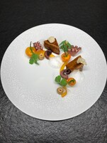 Um prato branco com diversos alimentos e guarnições.