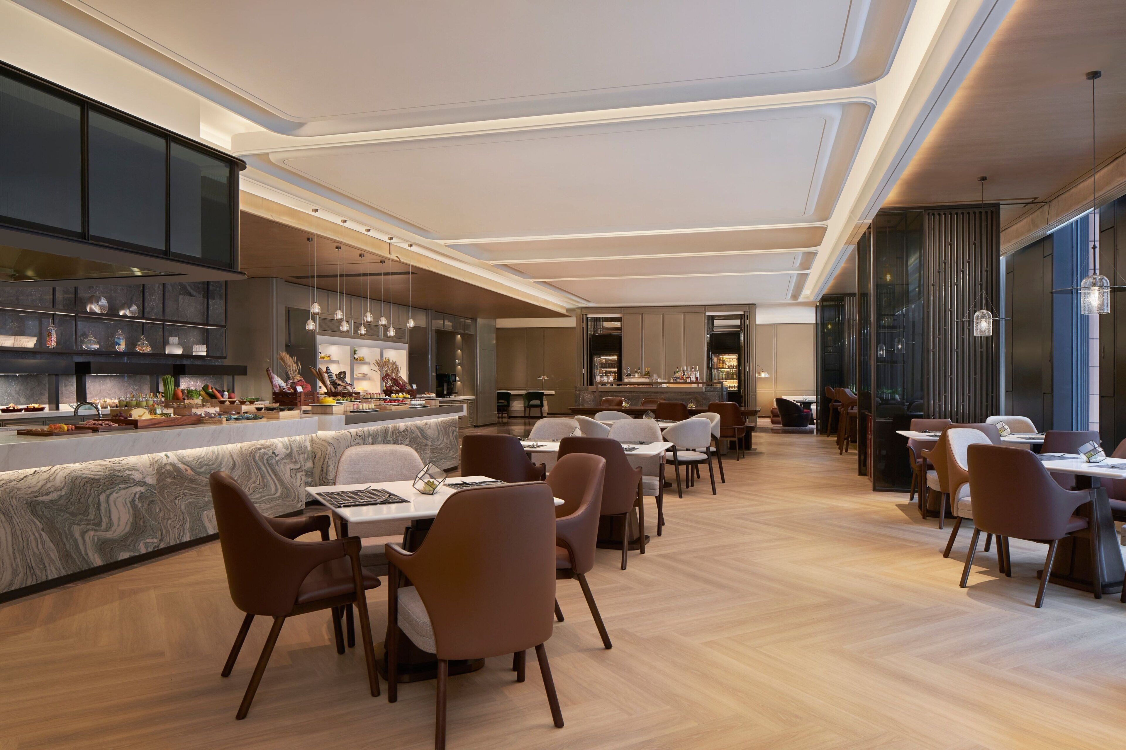 Restaurante moderno com balcão de mármore, soalho de madeira e mobiliário contemporâneo.
