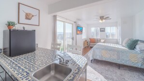 Um espaço compacto com cozinha compacta, cama, área de refeições e vista para o exterior.