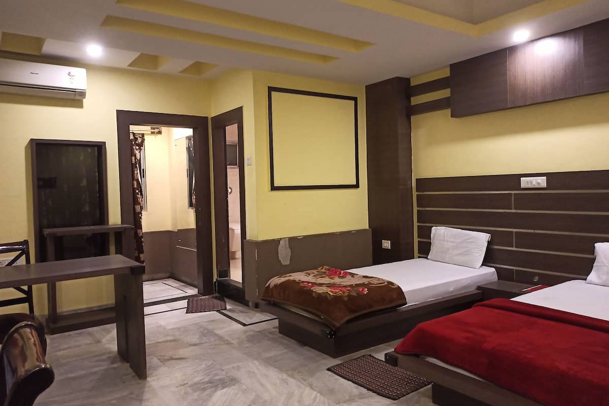 Quarto de hotel com cama, escrivaninha e ar condicionado.