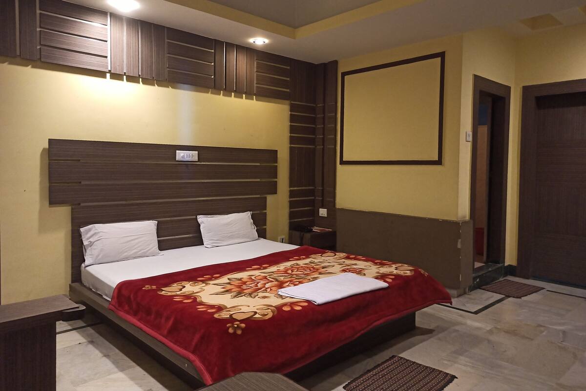 Quarto bem arrumado com uma cama grande, uma mesa de cabeceira e um criado-mudo.