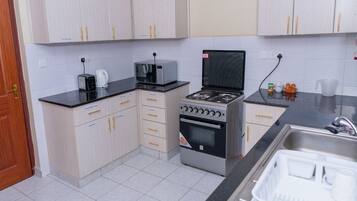 Um frigorífico, um micro-ondas, utensílios de cozinha